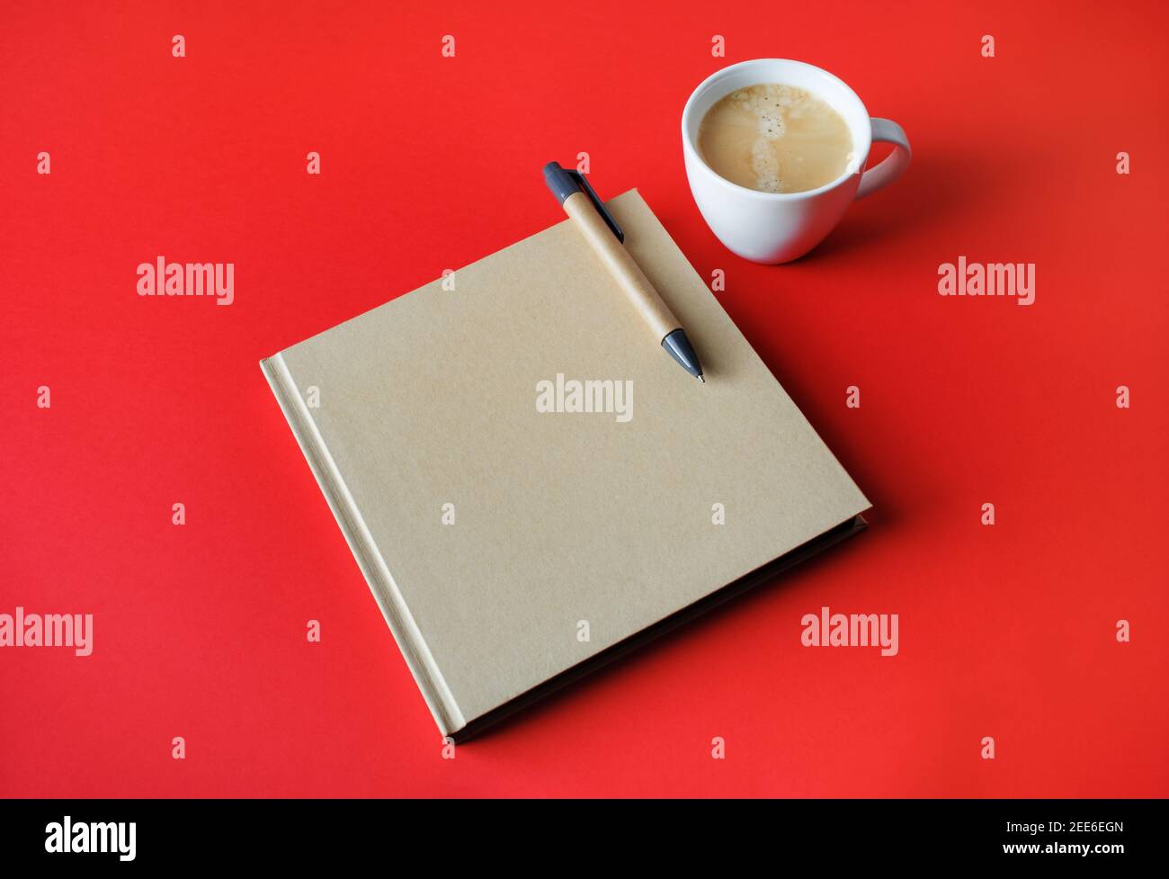 Closed blank book, coffee cup and pen on red paper background Stock ...