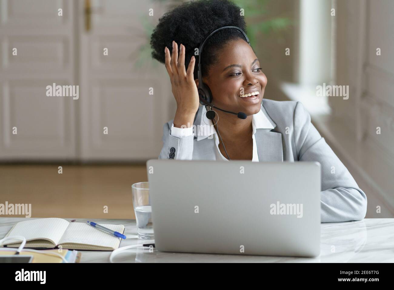 Black woman dispatcher agent wearing headset with microphone talking ...