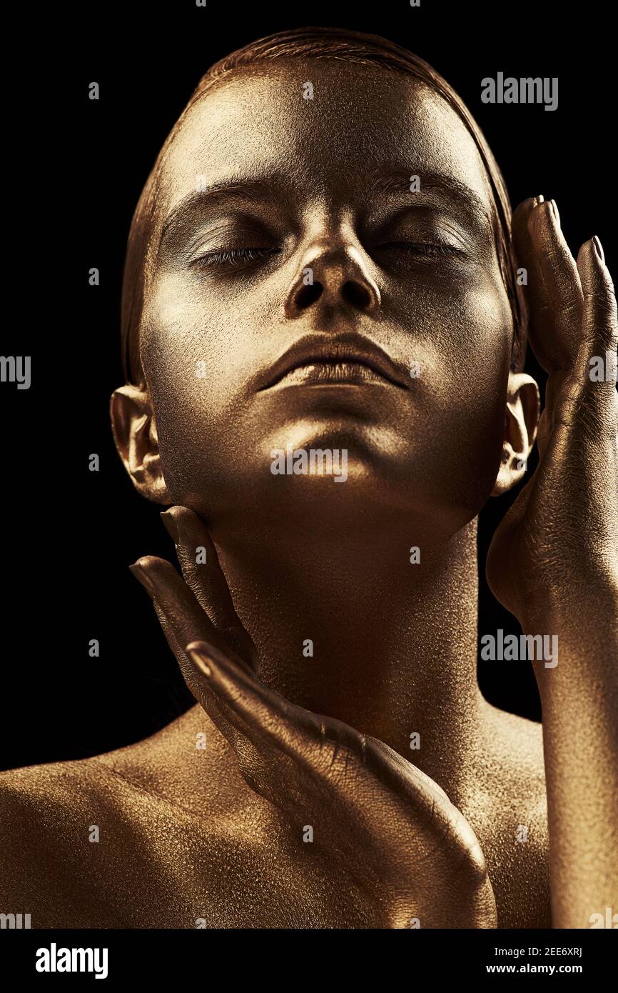 Beauty woman with golden skin on black background Stock Photo - Alamy