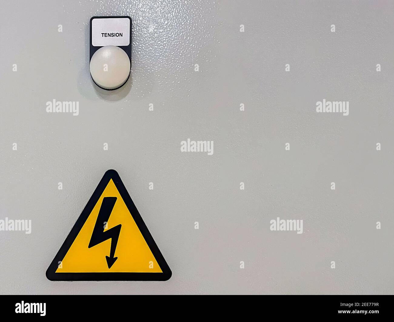 gray metal panel with a warning light with tension message and a high ...