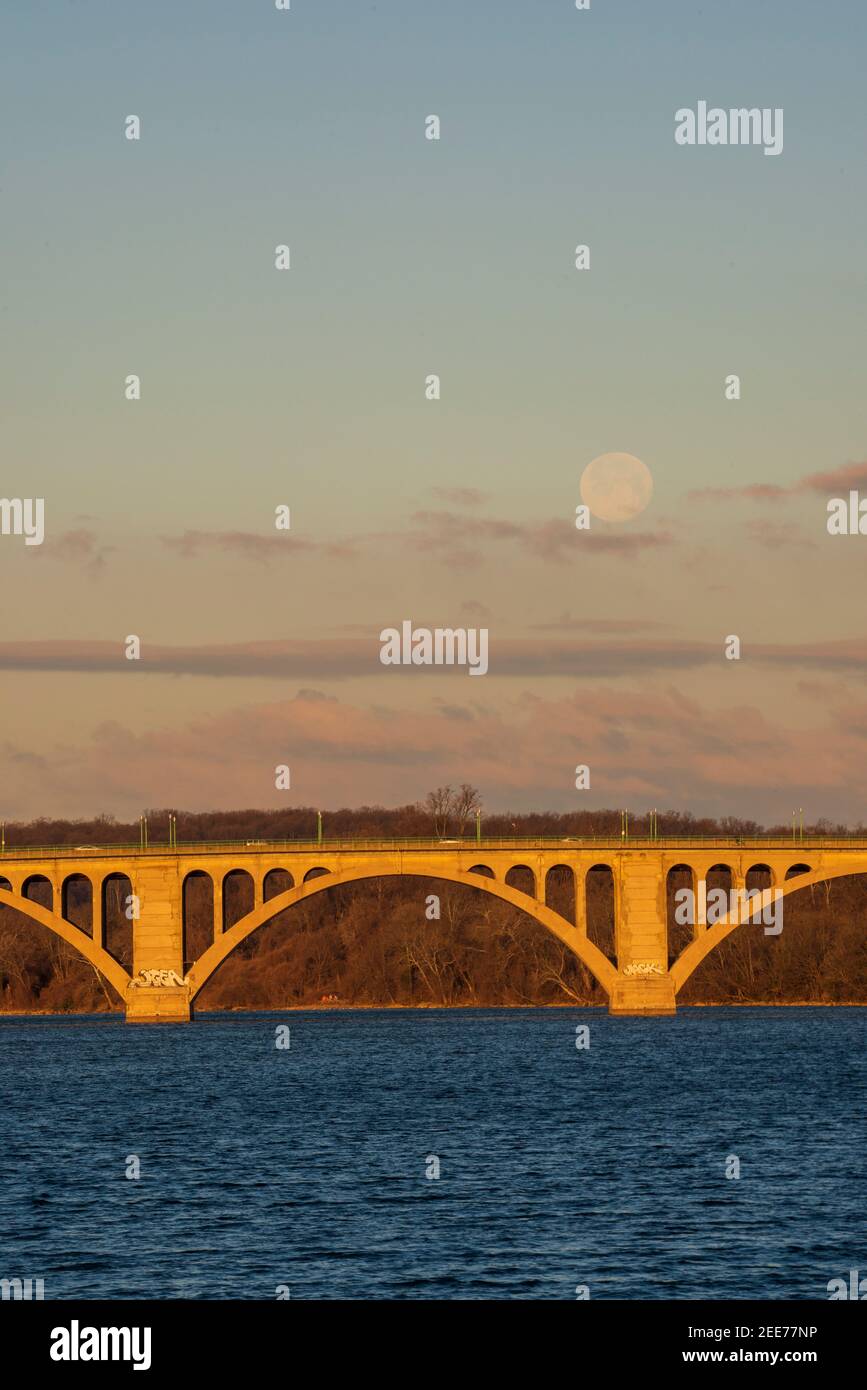 The full moon sets in the early morning light over Key Bridge in ...