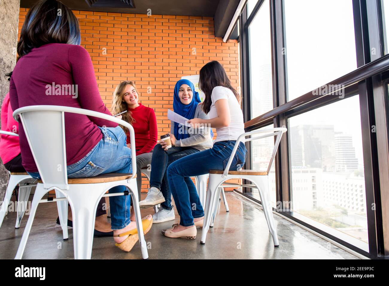 Diverse group of women in colorful clothes at the meeting, discussing ...