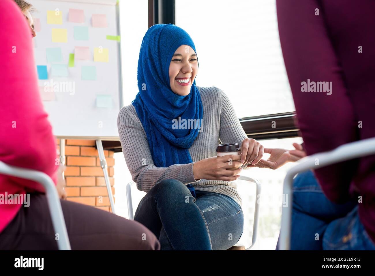 Young muslim woman talking and laughing with her friends happily in ...