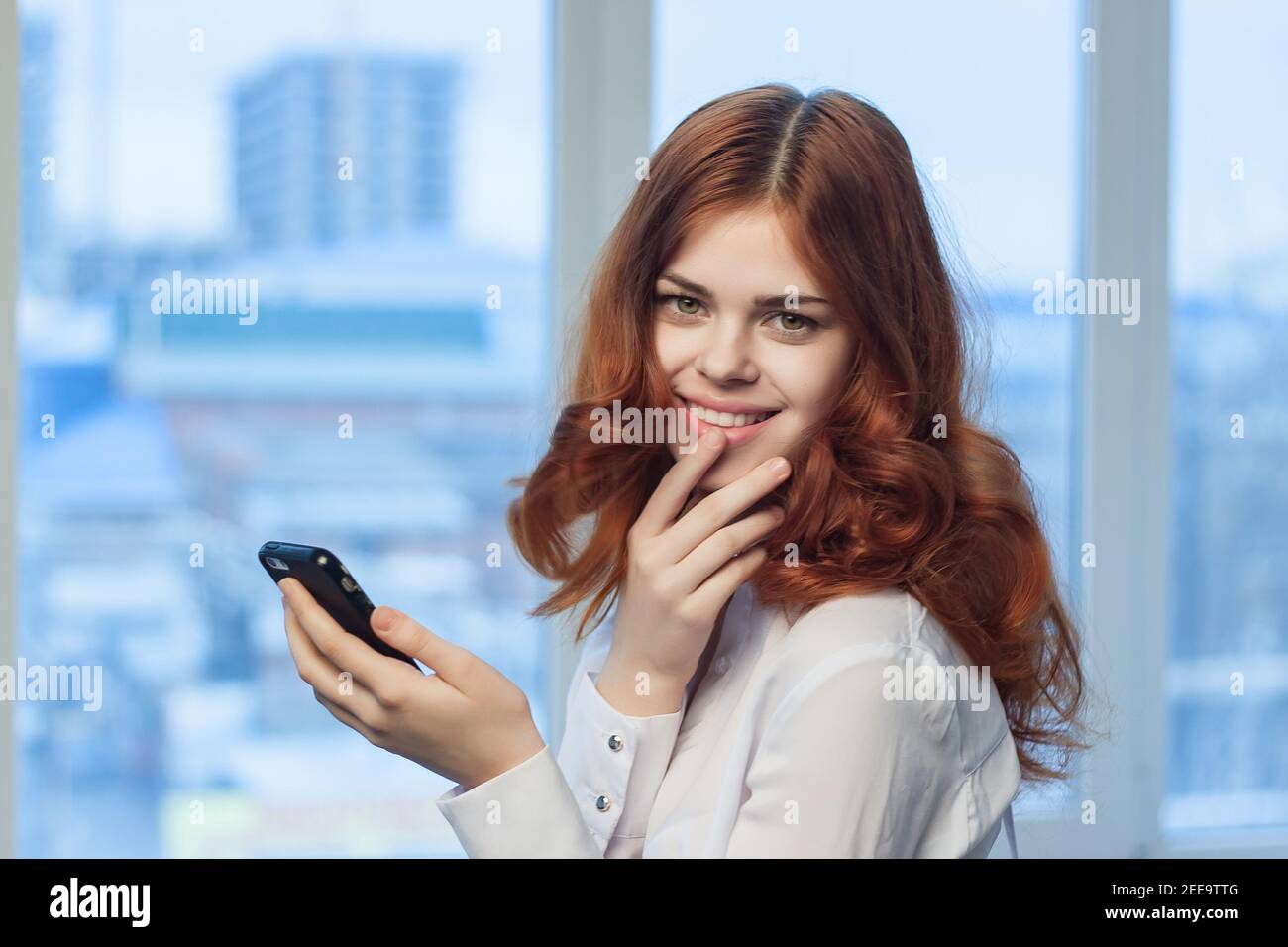 woman manager phones in hands communication office work Stock Photo - Alamy