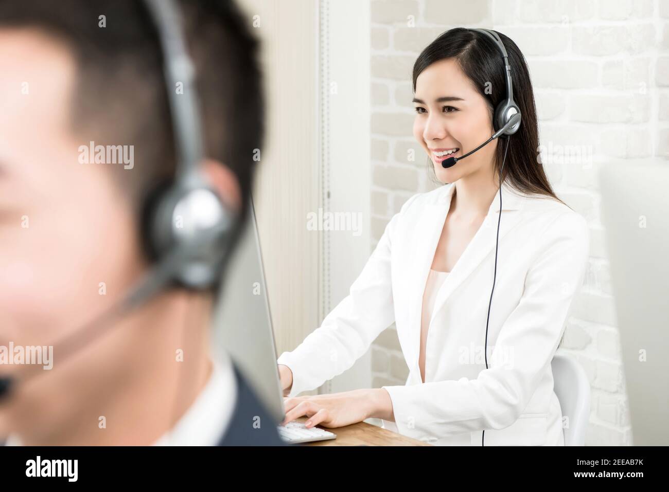 Smiling beautiful Asian woman telemarketing customer service agent ...