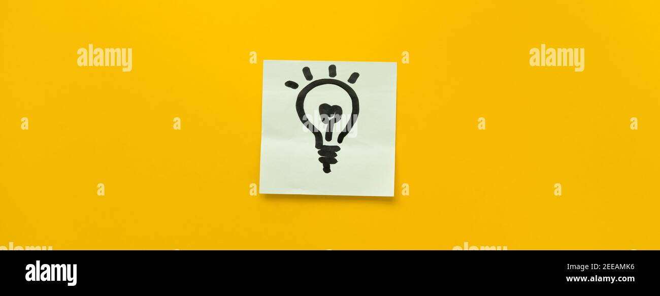 Hand drawn light bulb icon on sticky note paper representing ideas ...