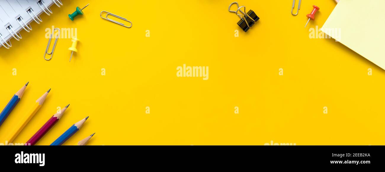 Colorful office and educational supplies on yellow paper, panoramic ...