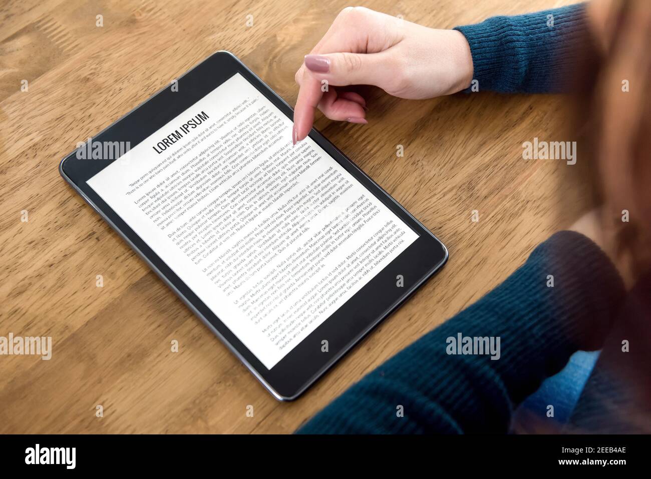 Female student reading e-book reader at the table, education technology ...