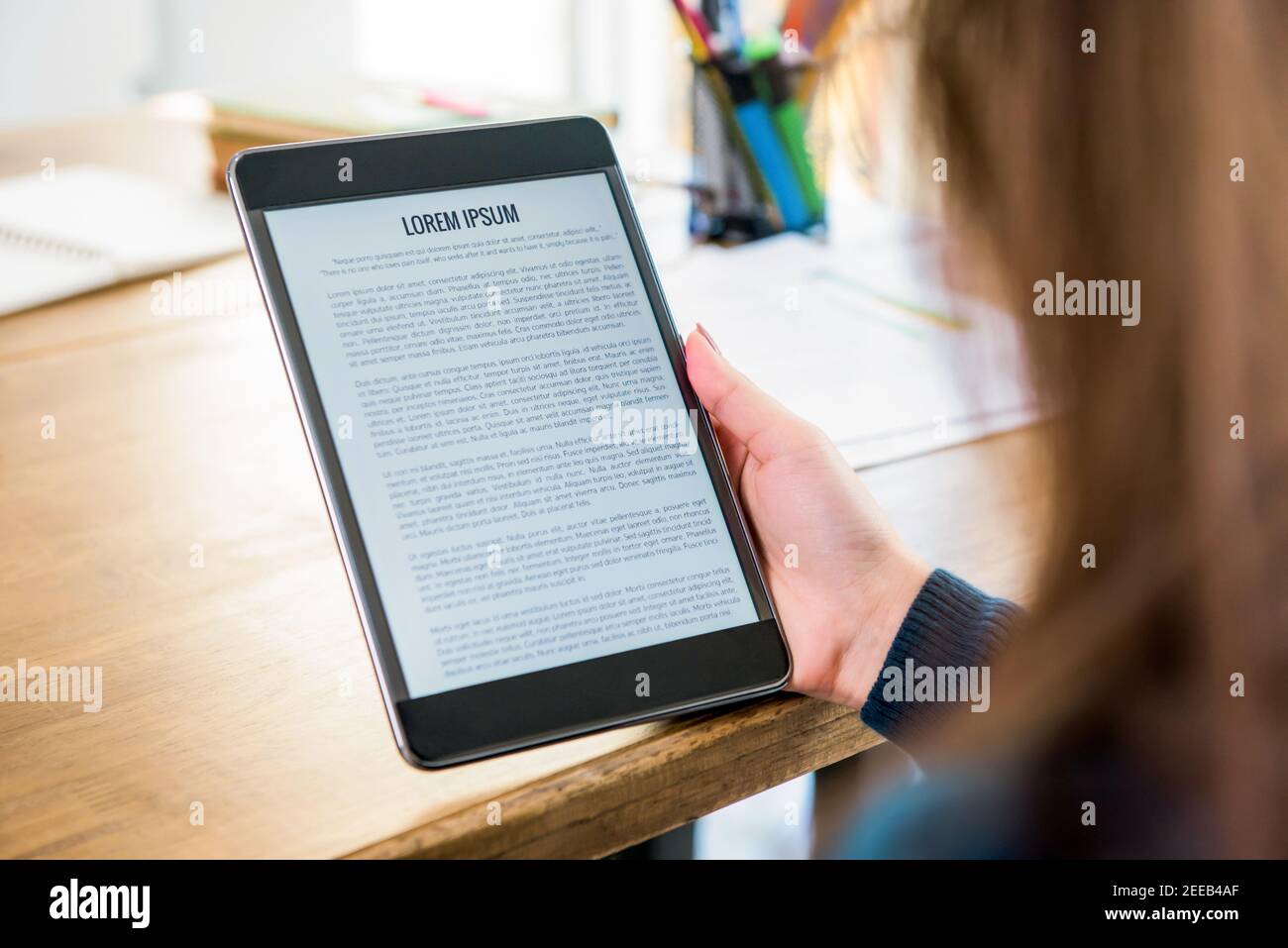 Female student reading e-book reader at the table, education technology ...