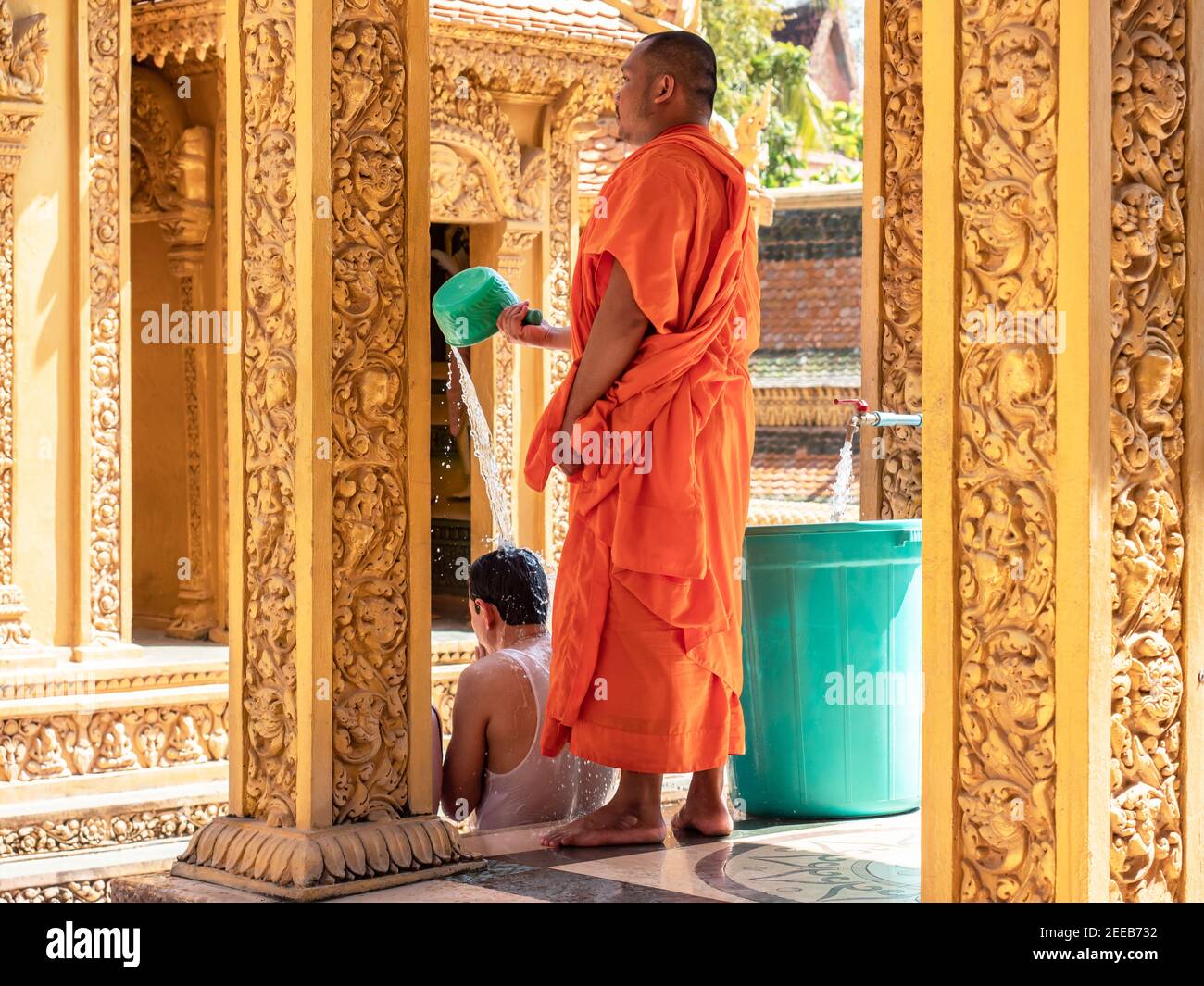 Monk performing a water blessing on a man at Wat Kean Kliang, a ...