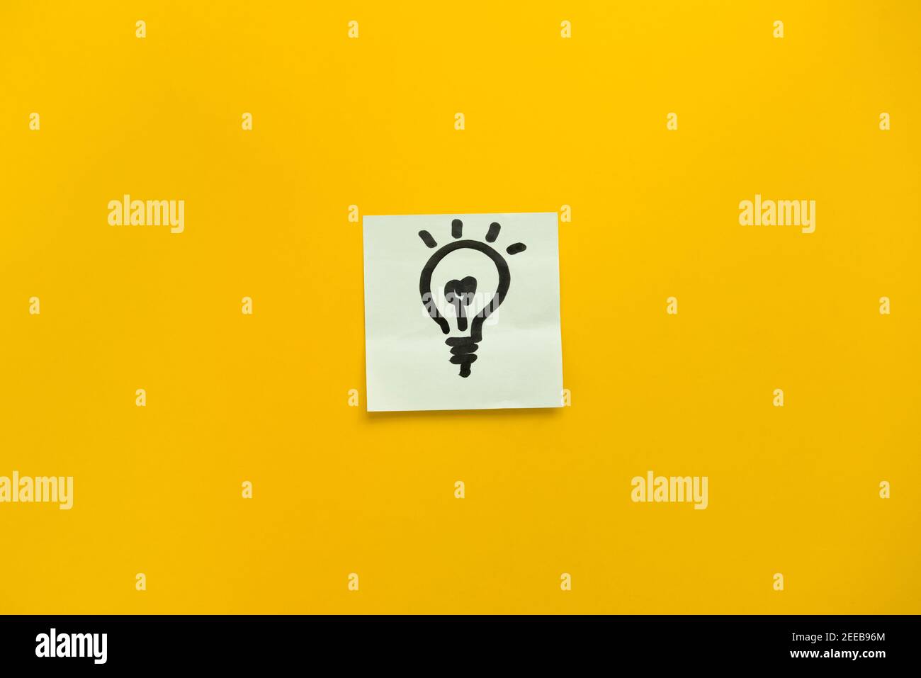 Hand drawn light bulb icon on sticky note paper representing ideas ...
