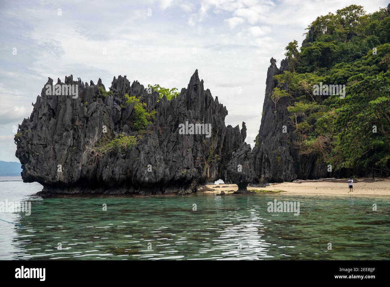 Seaside landscape with white sand beach and black cliff. Tropical ...