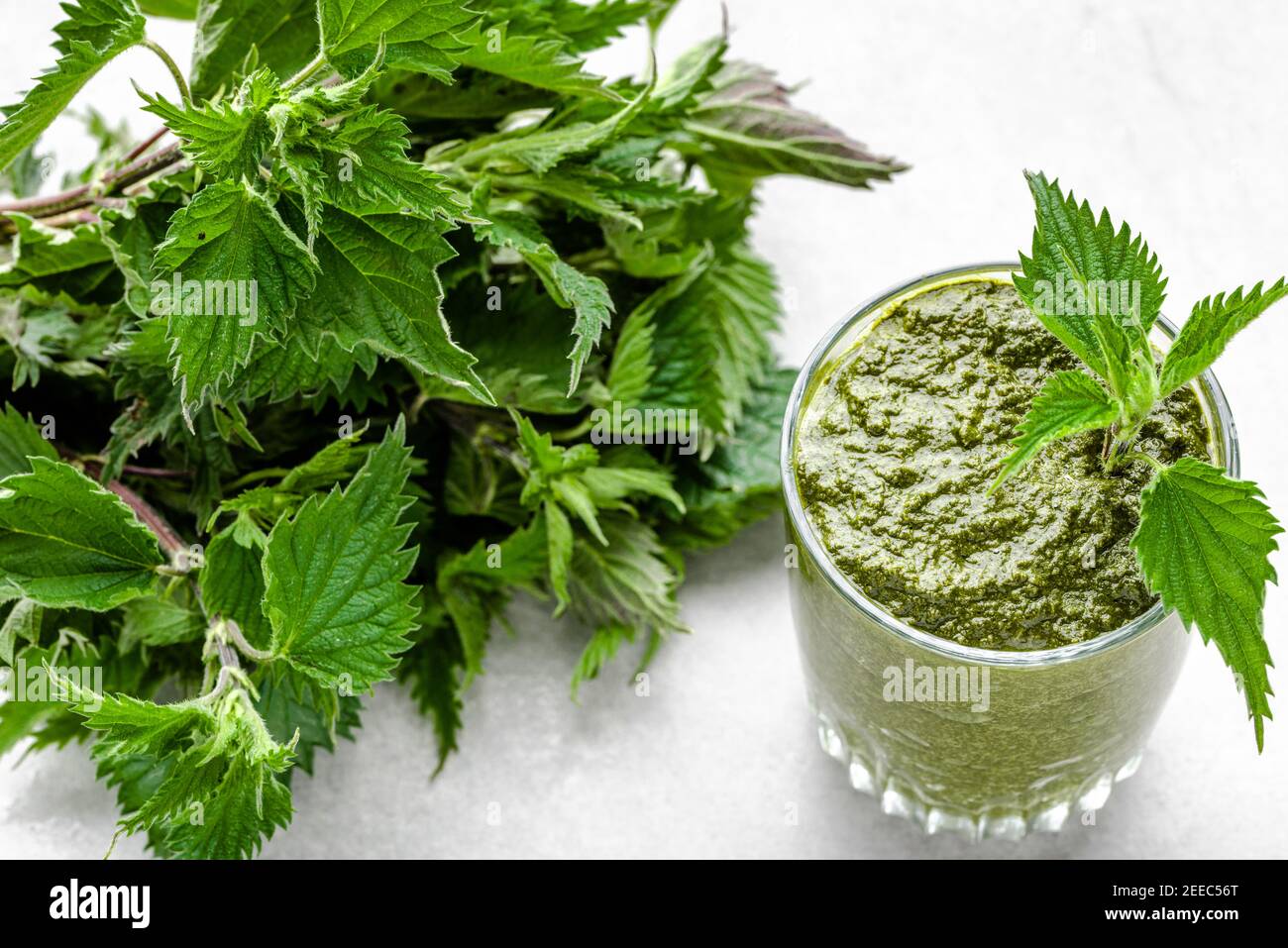 Healthy smoothie with green leaves of nettle in jar on white background ...