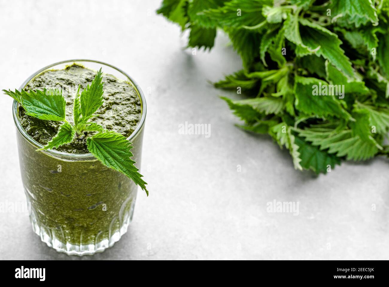 Healthy smoothie with green leaves of nettle in jar on white background ...