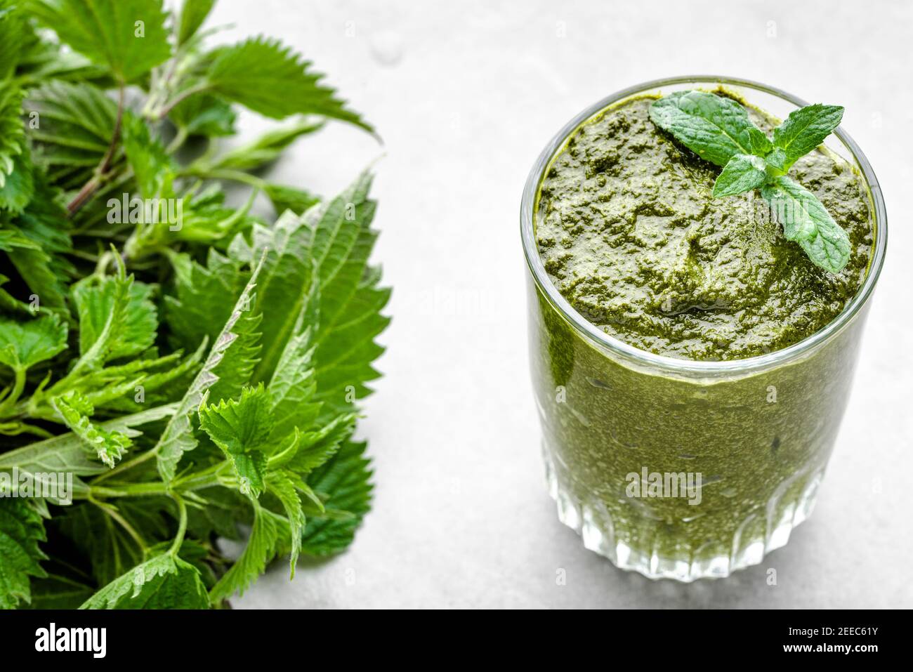 Healthy smoothie with green leaves of nettle in jar on white background ...