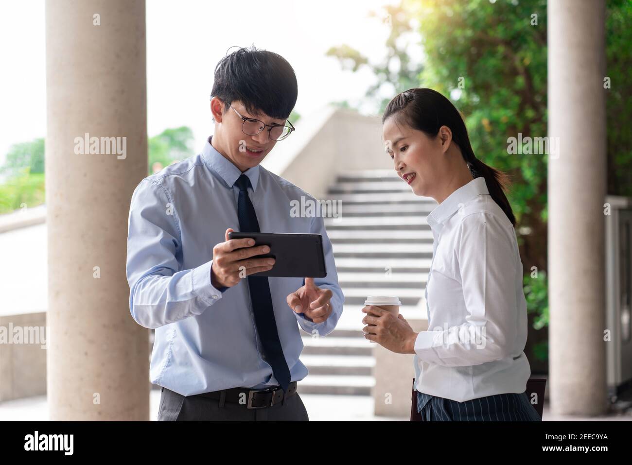 Business colleagues discussing work issues outdoor near the office ...