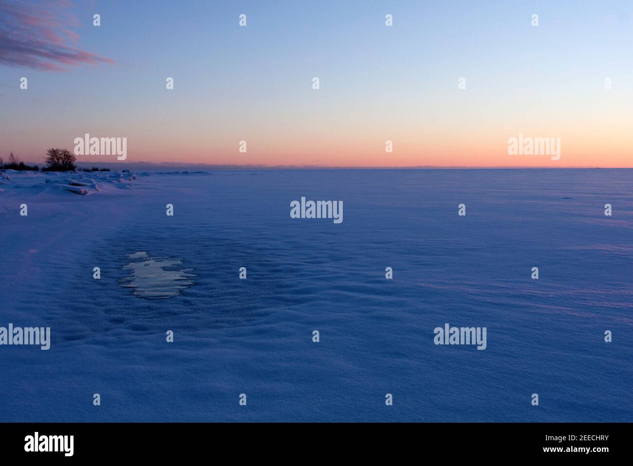 Sunset from the shore by the midwinter sea, noon. Cold January day ...