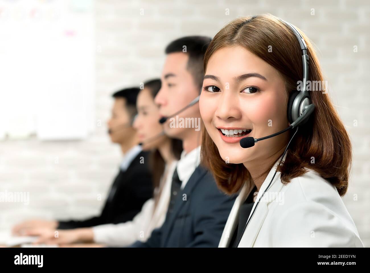 Smiling beautiful young Asian woman telemarketing customer service ...
