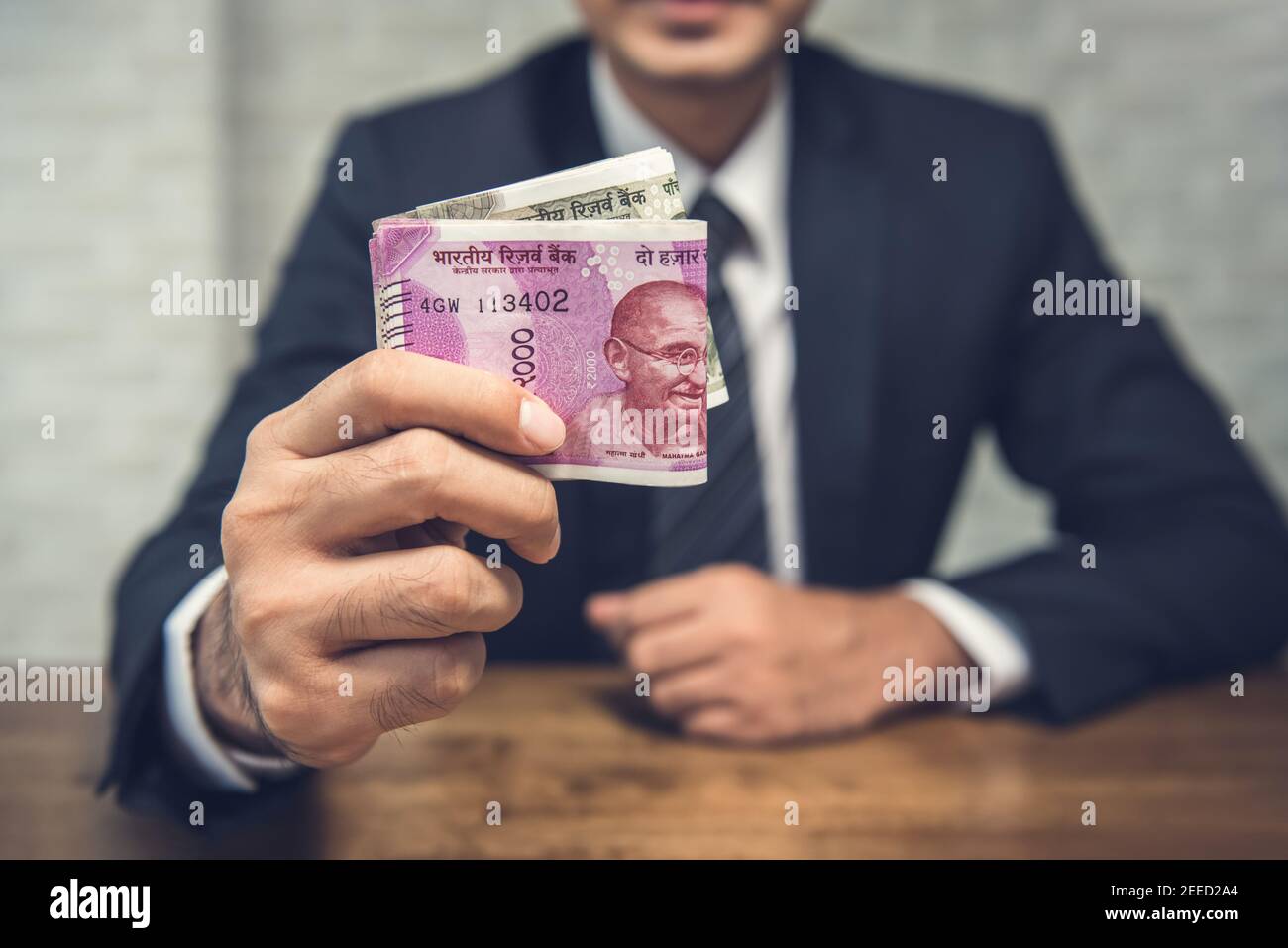 A businessman giving money in the form of Indian Rupees for services ...