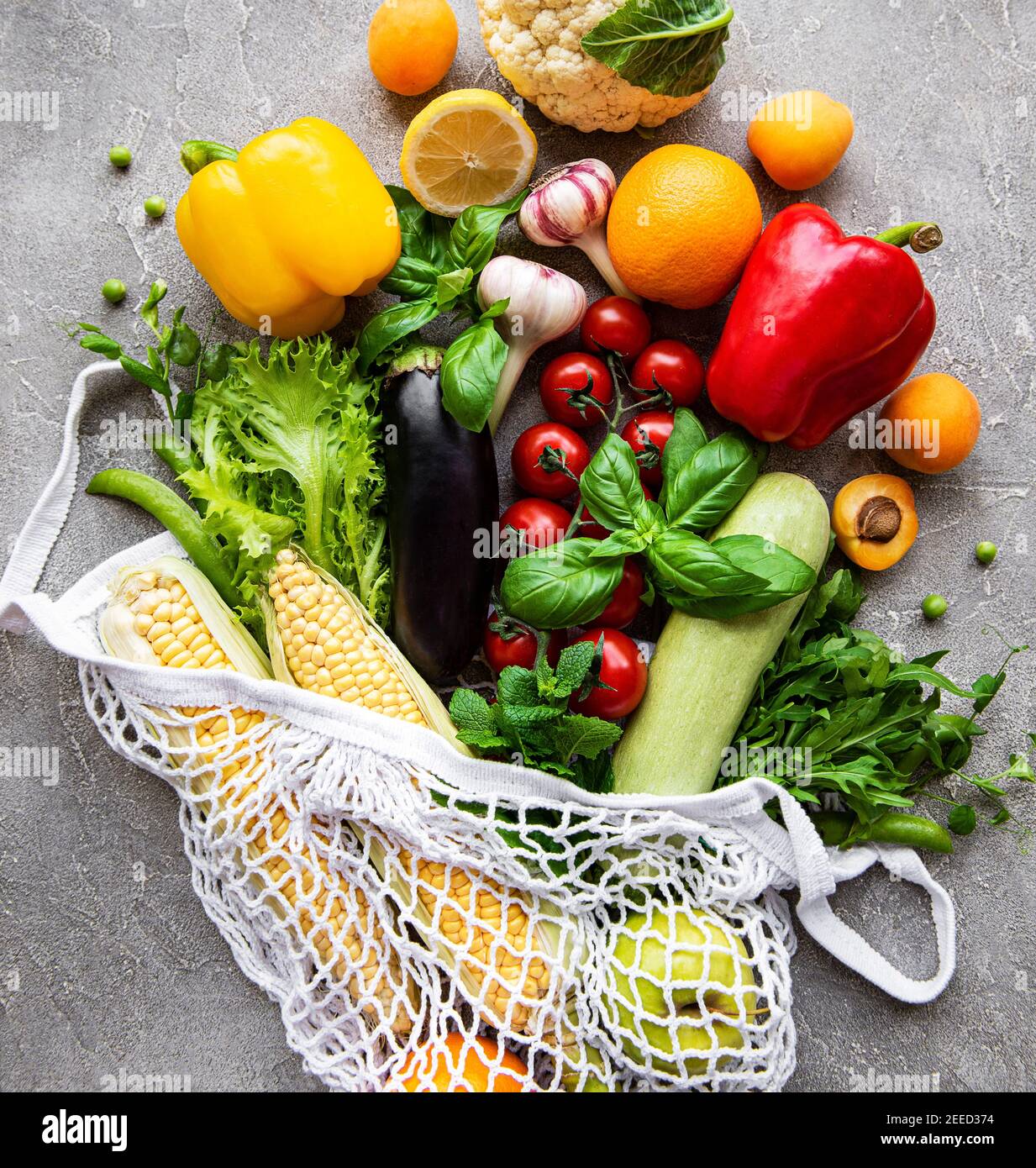 Fresh vegetables and fruits on eco string bag on a concrete background ...