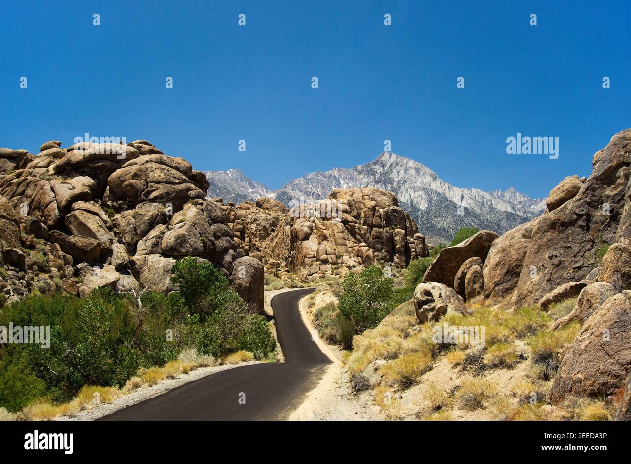 The rocks of "Alabama Hills" with a winding road and the Sierra Nevada ...