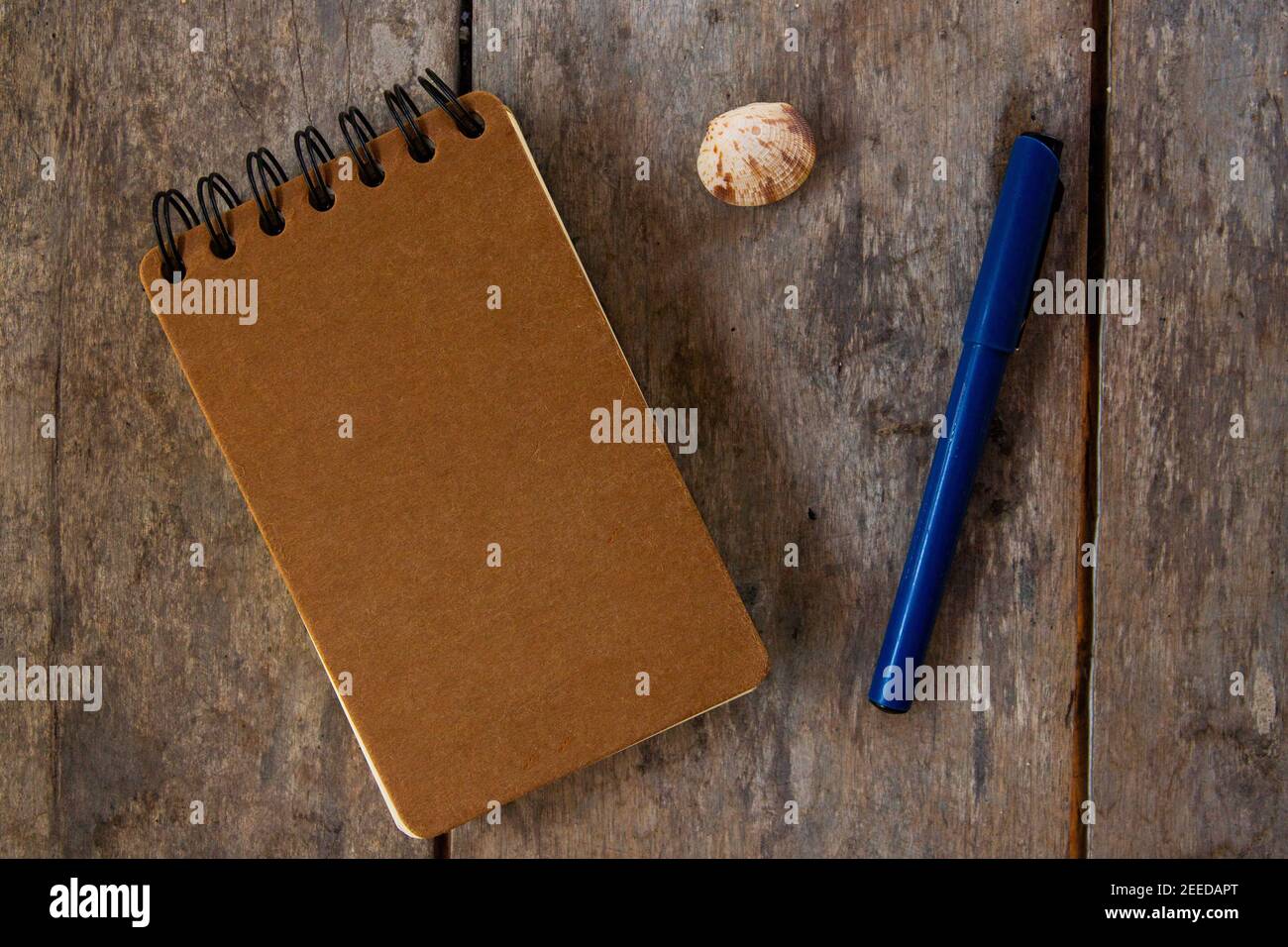 Spiral notepad craft cover and pen on wooden background. Empty ...