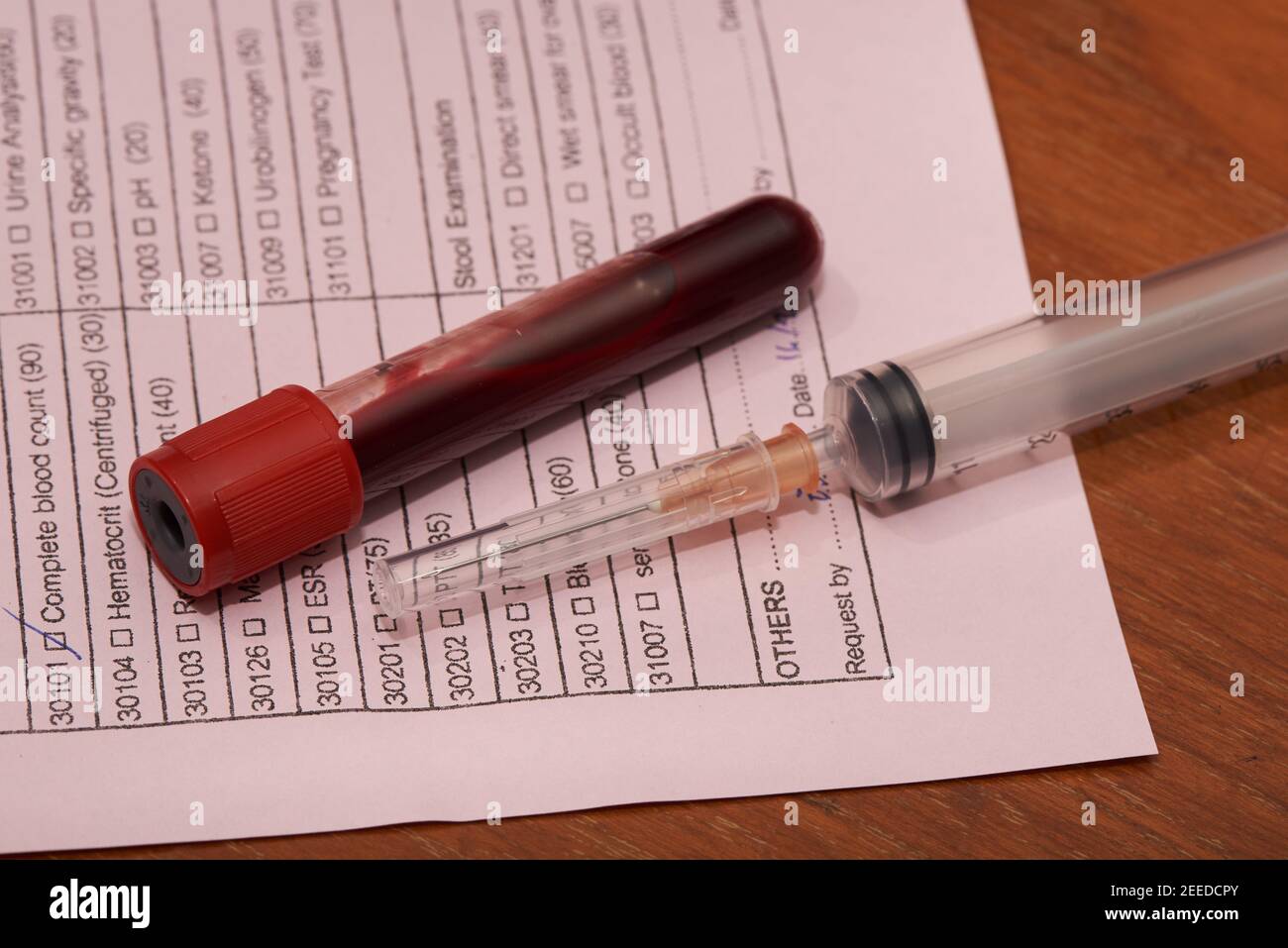 Syringe and blood sample in test tube for hematology examination ...