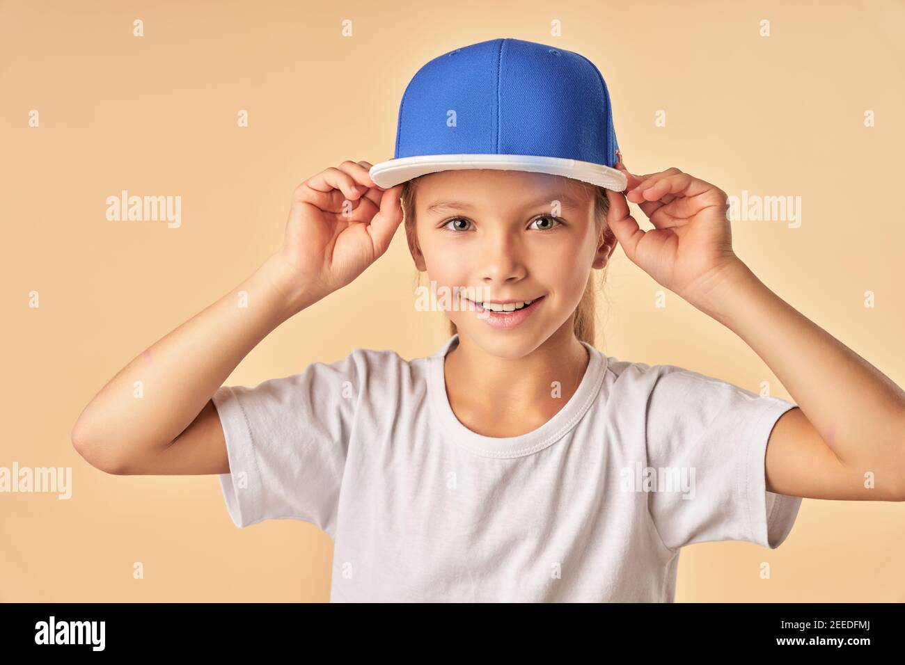 Cheerful female child looking at camera and smiling while standing ...