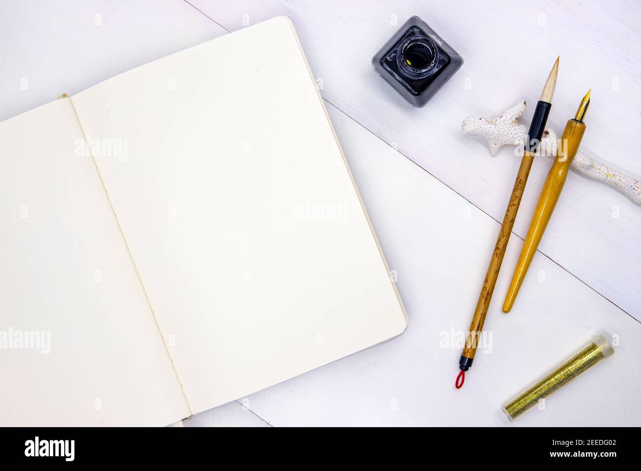 Blank page of sketchbook with calligraphy tools. Notebook top view ...