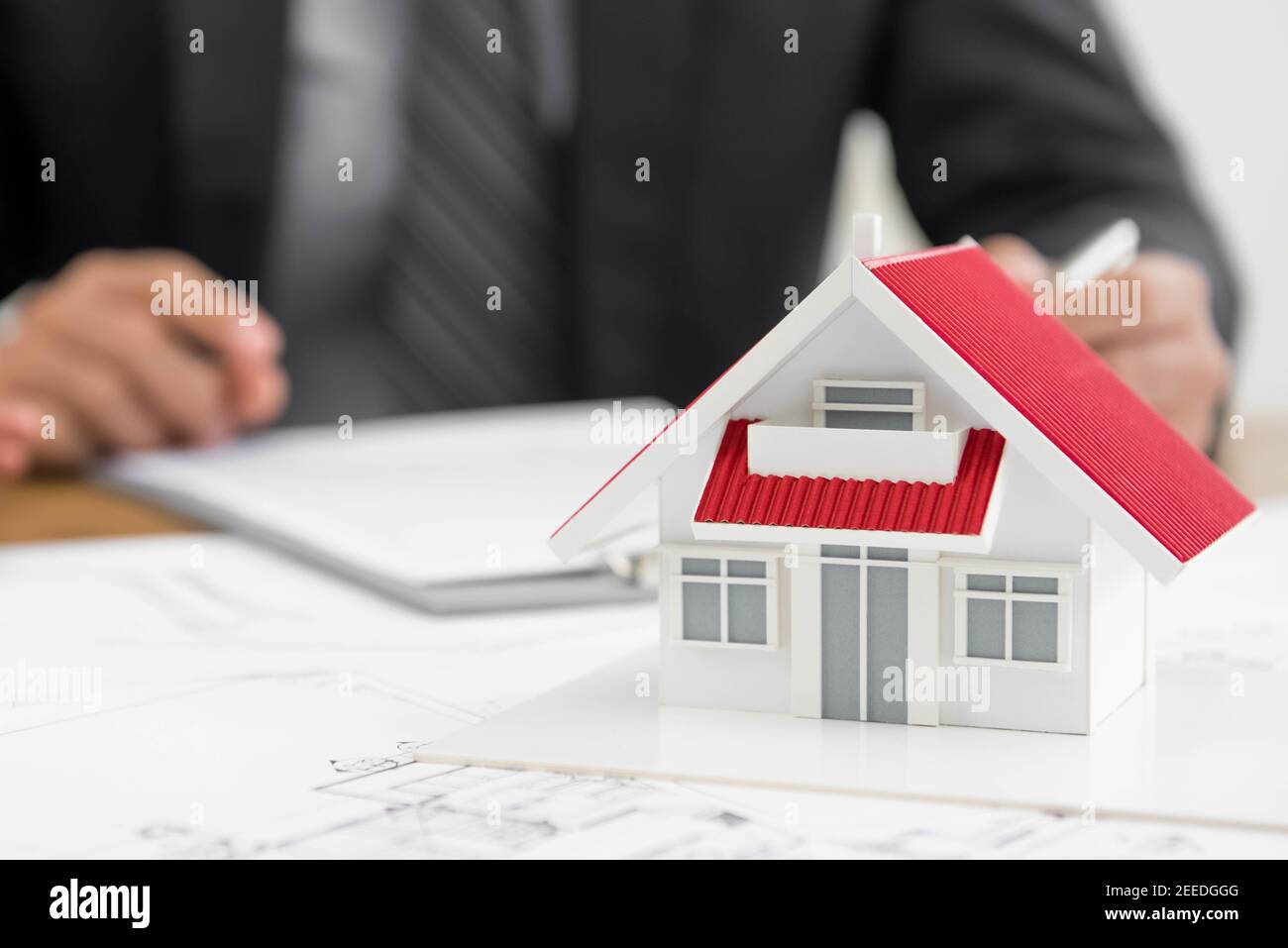 Architect (or real estate agent) working on house model and design ...