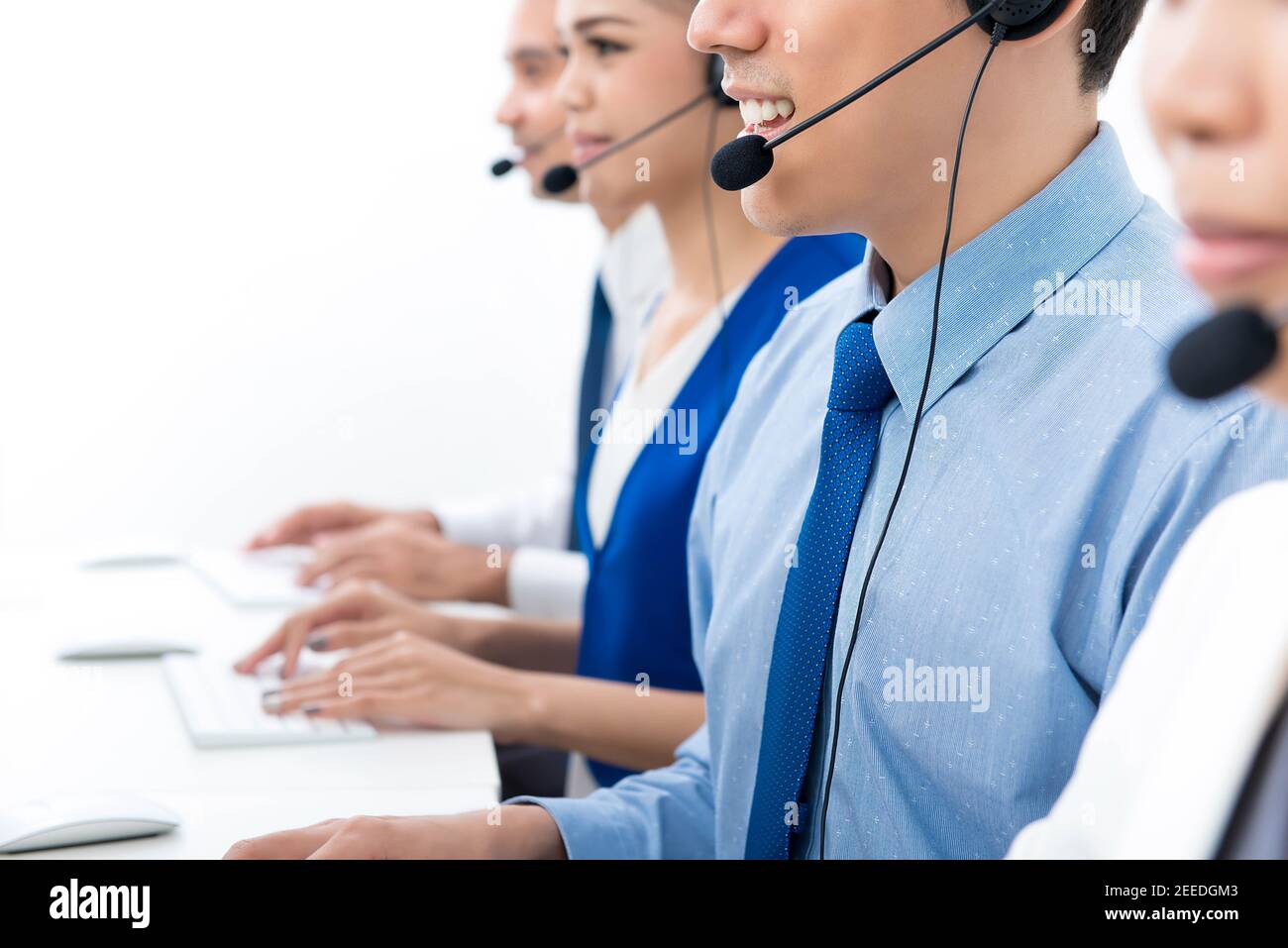 Call centre agents talking on the phone to customers with a friendly ...