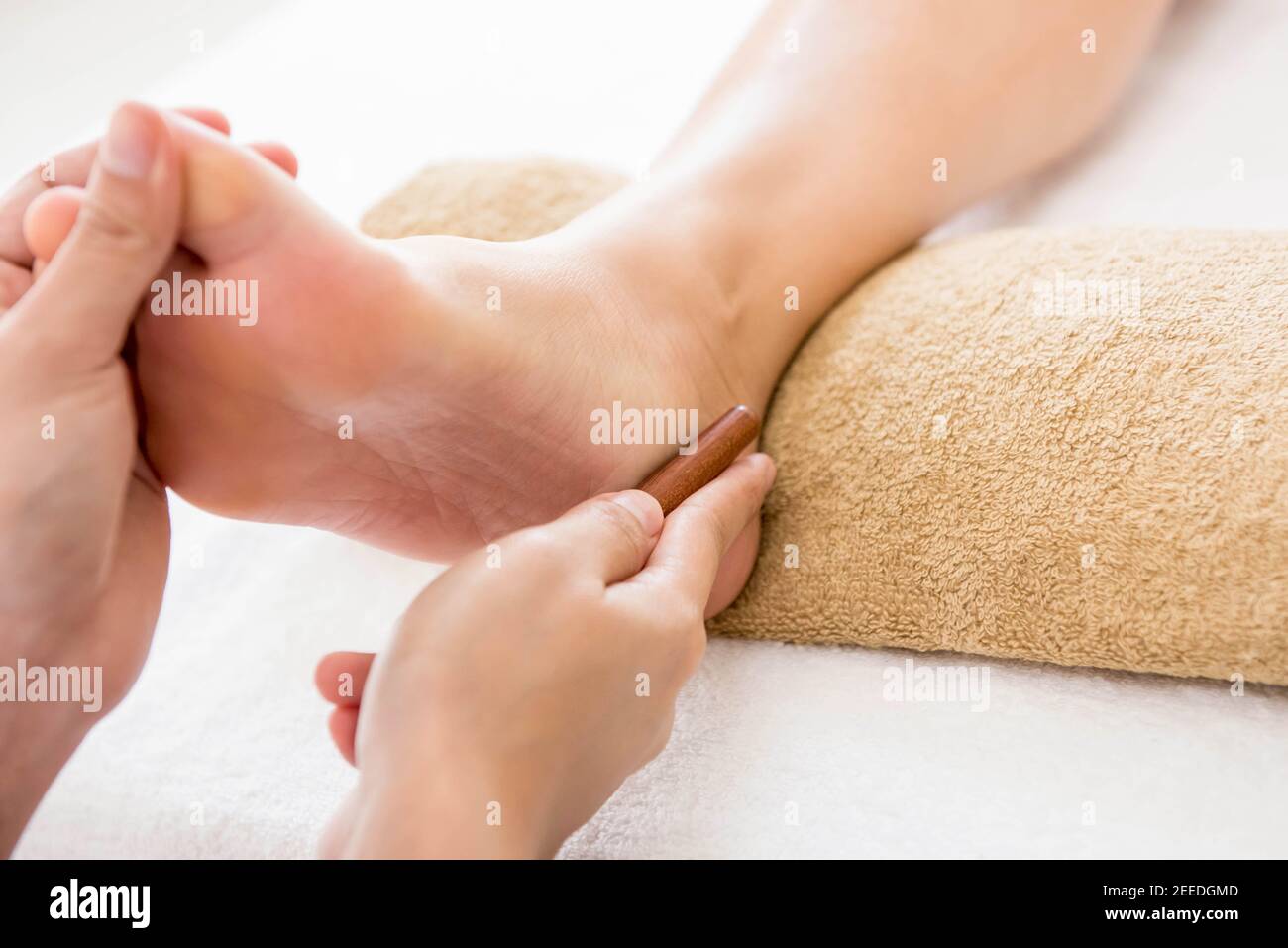 Professional therapist giving relaxing reflexology foot massage to a ...