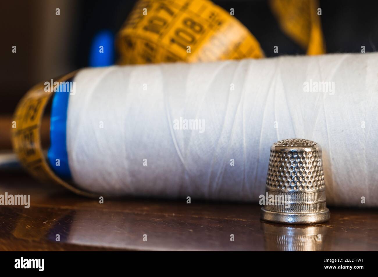 Close-up of thread, tape measure, scissors, thimble and dressmaker's ...