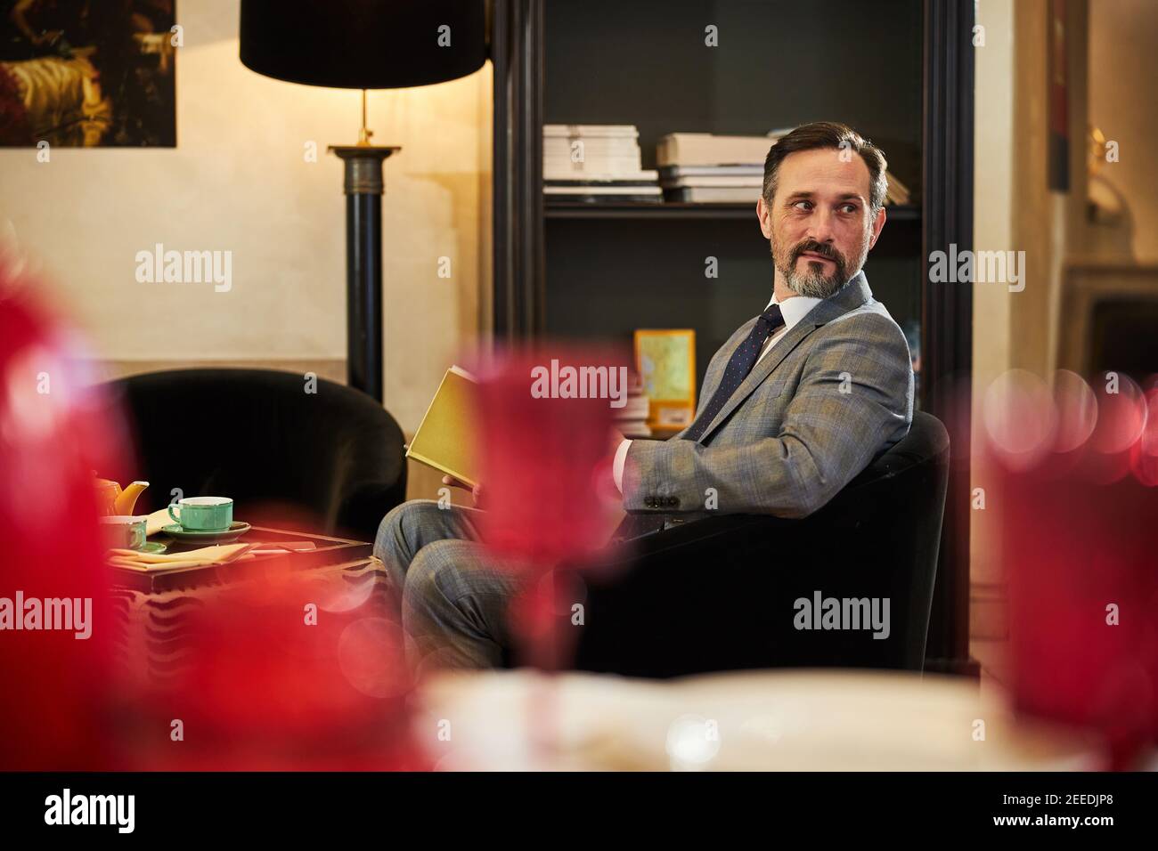 Brunette man looking interested while chilling in the lounge Stock ...