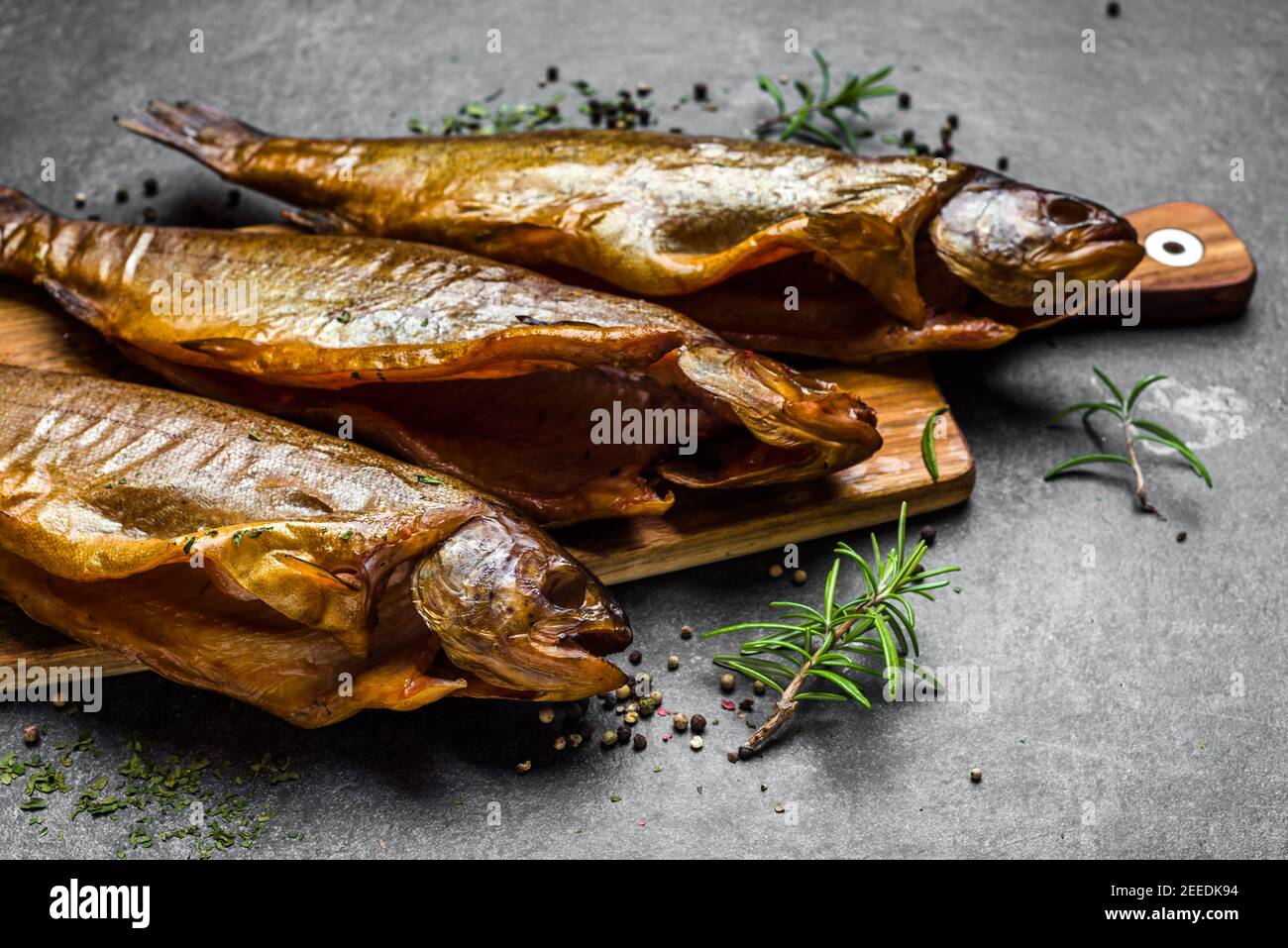 Smoked fish with spices on dark background Stock Photo - Alamy