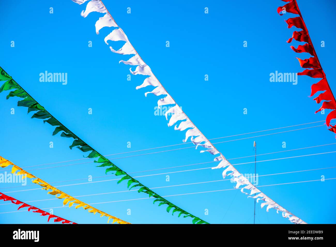 Colorful flag ribbons in sunny blue sky. Festival flag decor. Summer ...