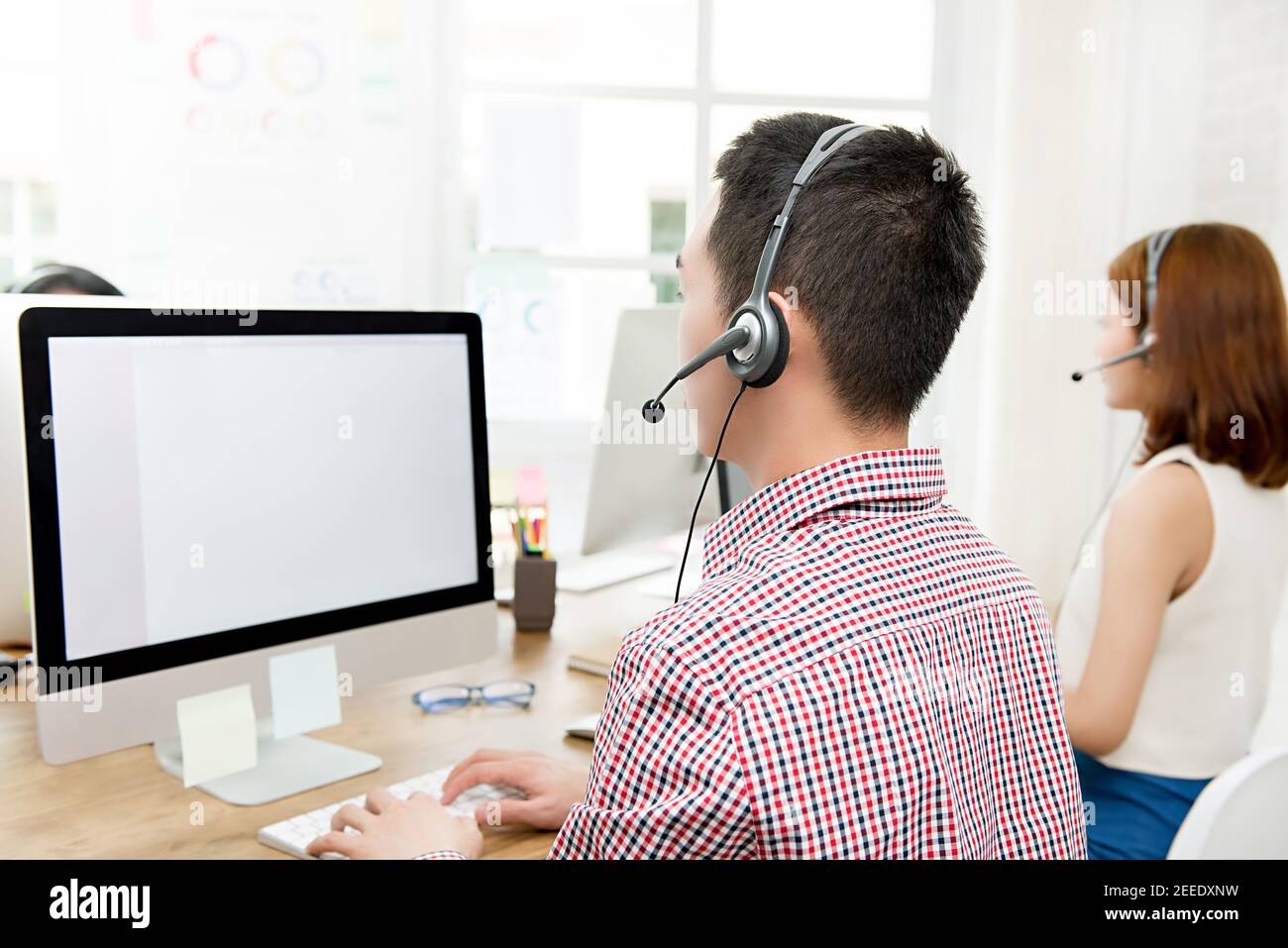 Back view of Asian telemarketing customer service agent team working in ...