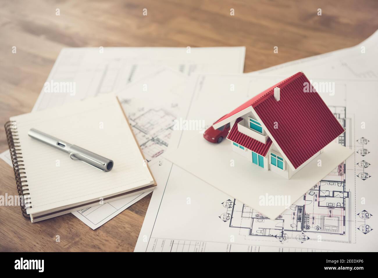 Blueprints, house model, notebook and pen on the table - architecture ...