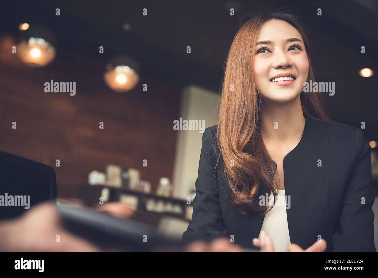 Young smiling Asian business woman meeting with client in cafe Stock ...