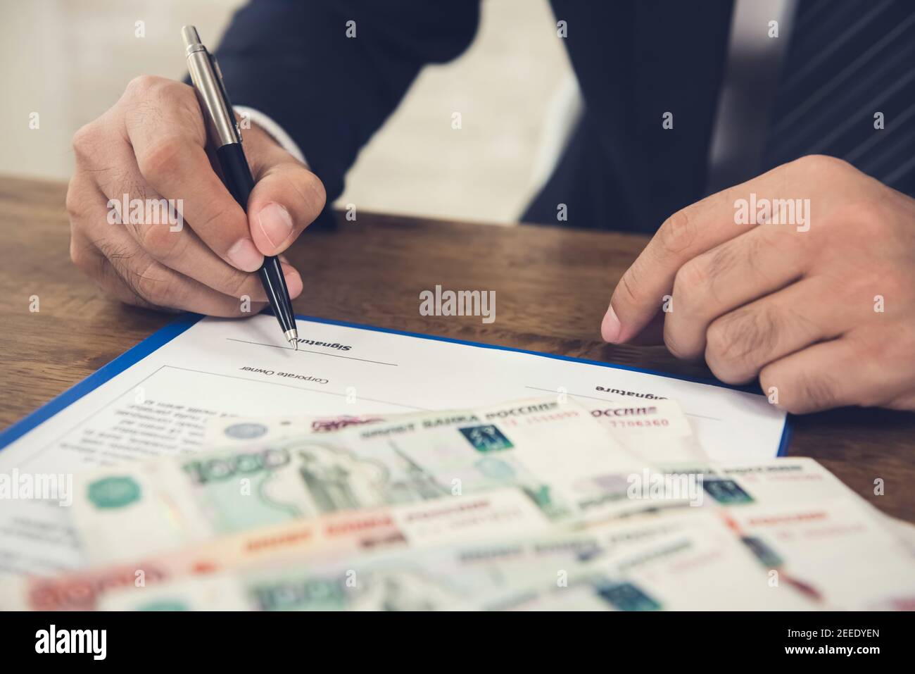 Businessman signing agreement contract paper with money, Russian ruble ...