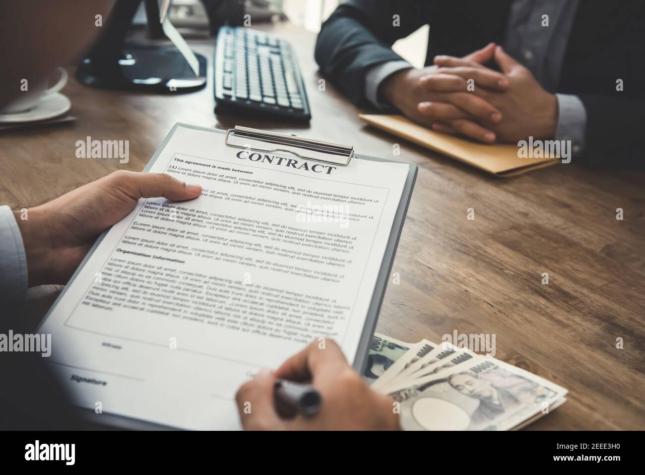 Businessman signing contract with money, Japanese yen banknotes, on the ...