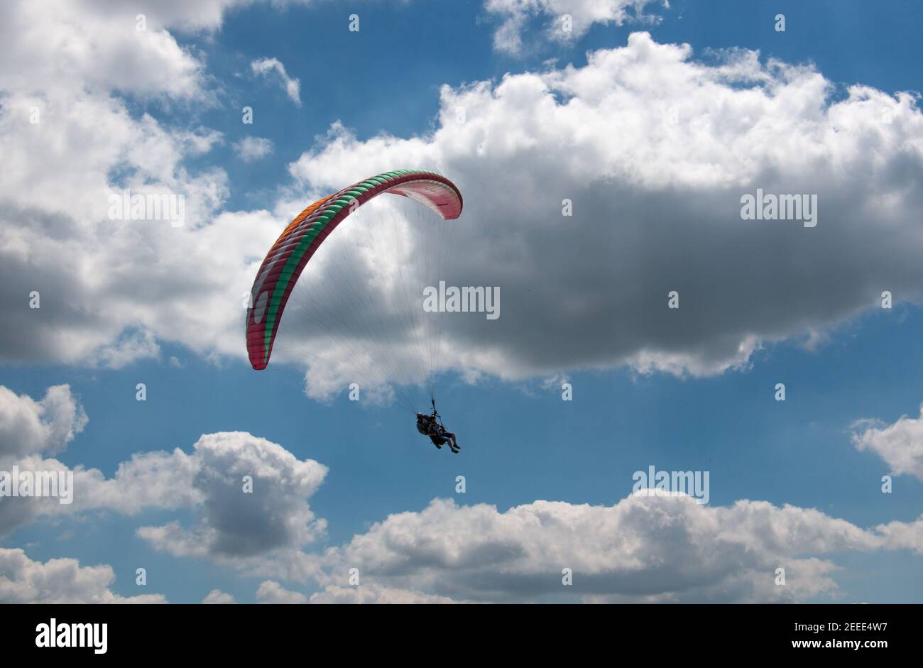 Two seated paraglider flying is cloudy sky Stock Photo - Alamy