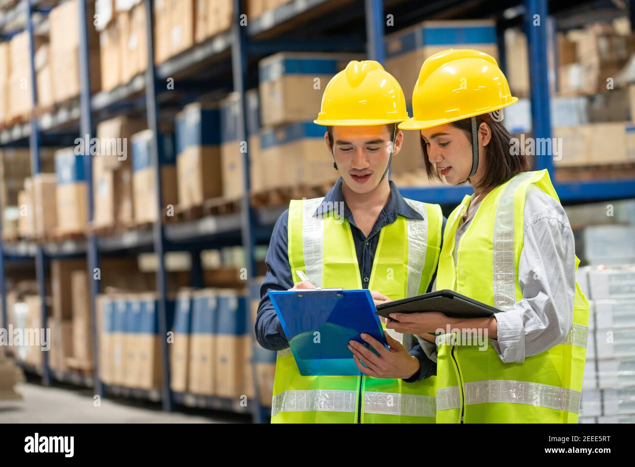 Warehouse worker checking packages on shelf in a large store Stock ...