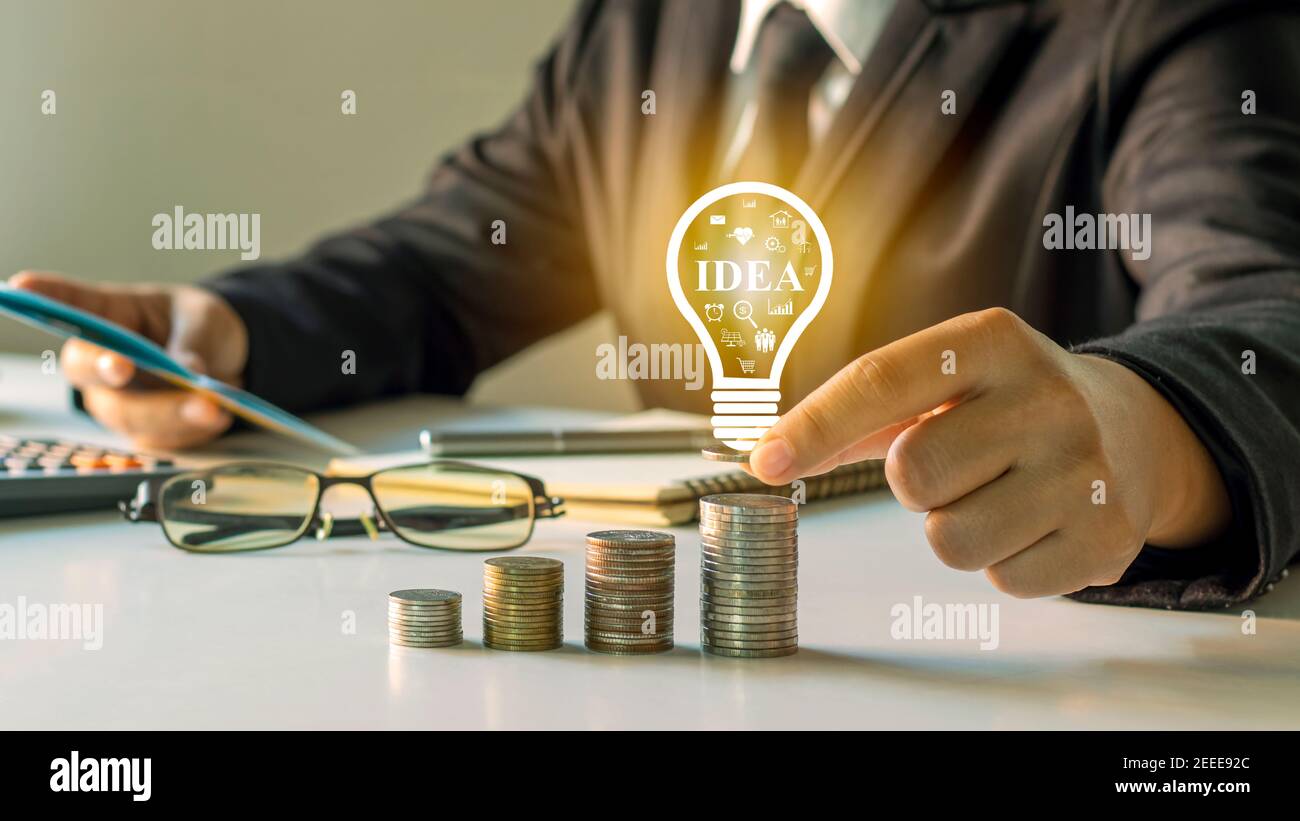 Businessman holding a light bulb, ideas on his desk, ideas for finance ...