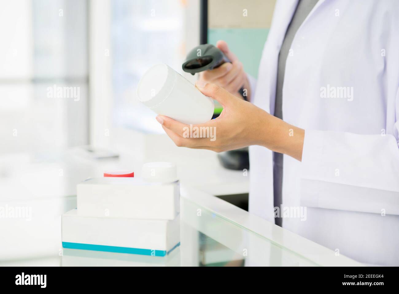 Pharmacist scanning medicine bottle with barcode scanner in pharmacy ...