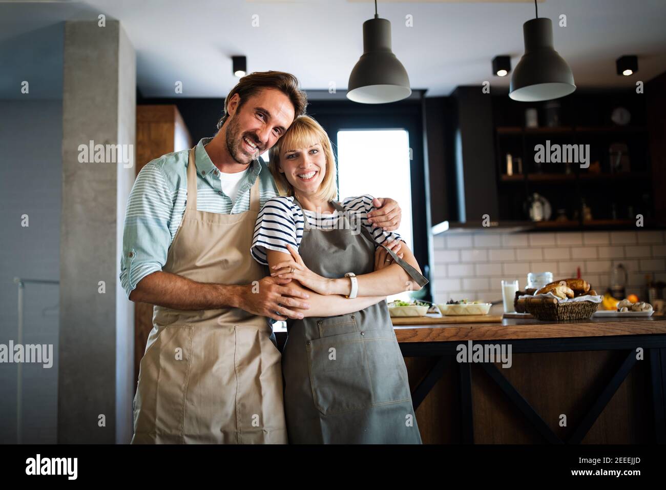 Happy couple cooking healthy food and having fun together in their ...