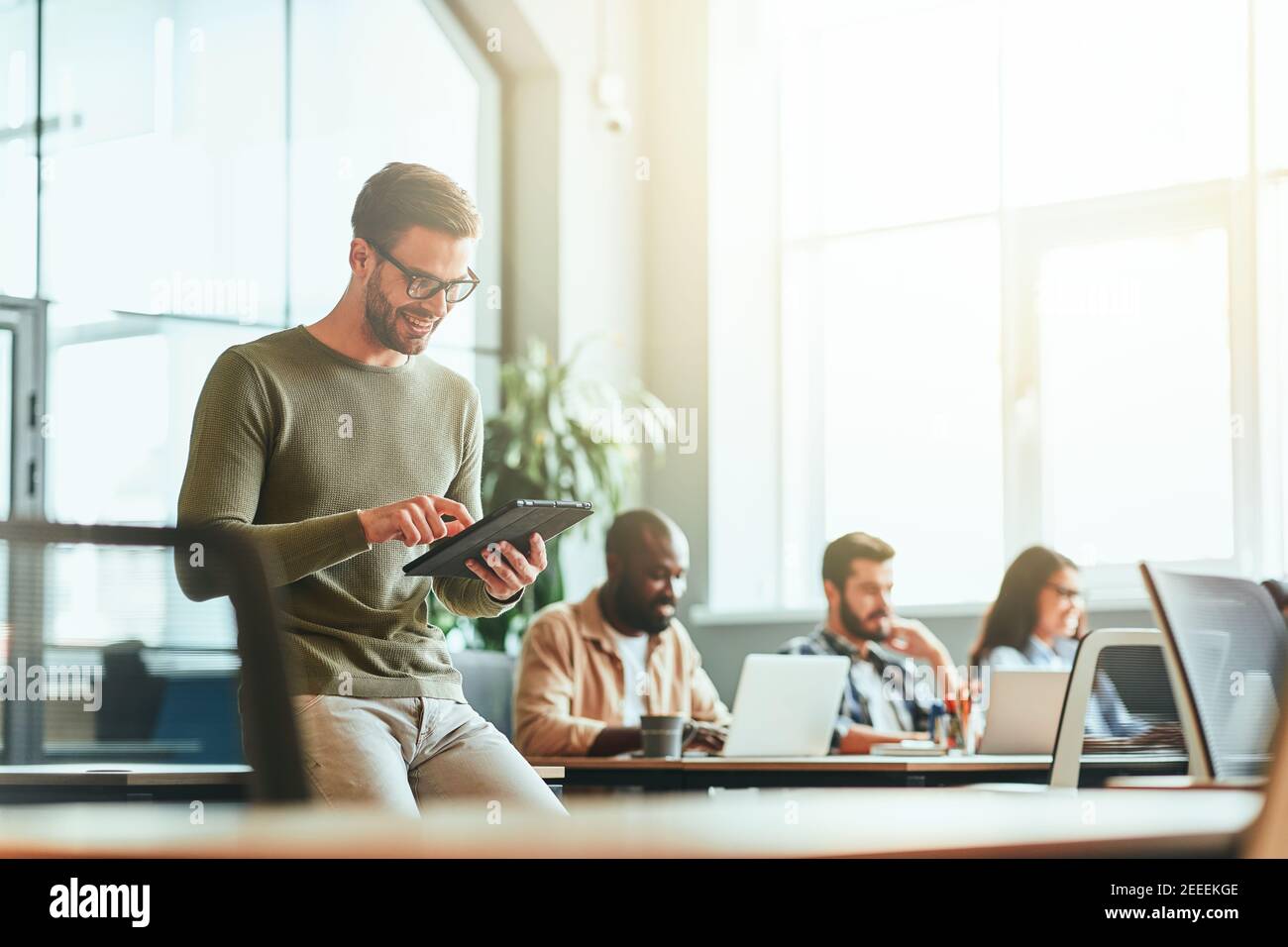Joyous young gentleman using his tablet for work Stock Photo - Alamy