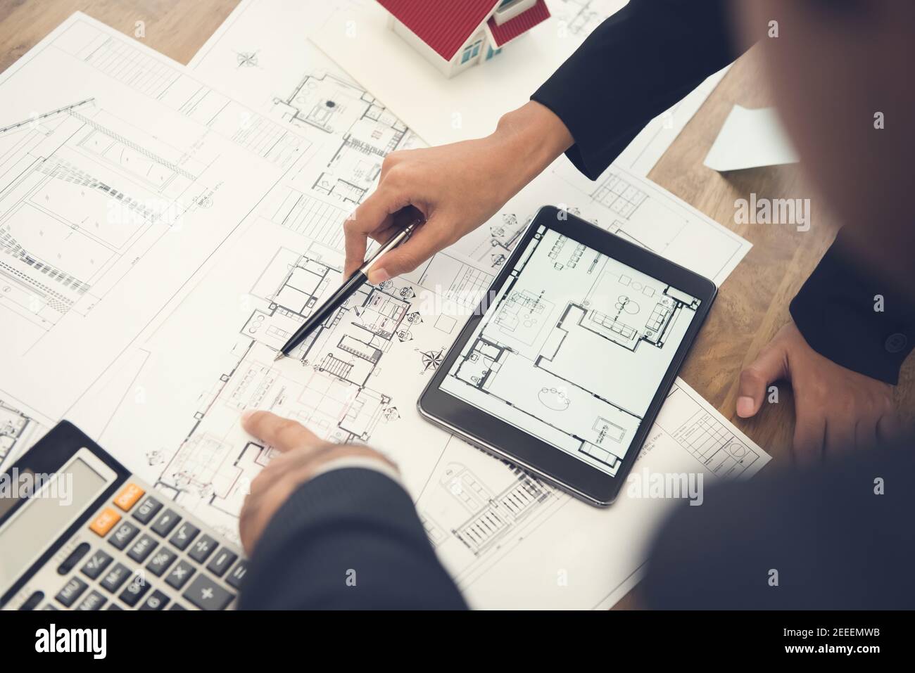 Architects or interior designers discussing floor plan blueprints on ...