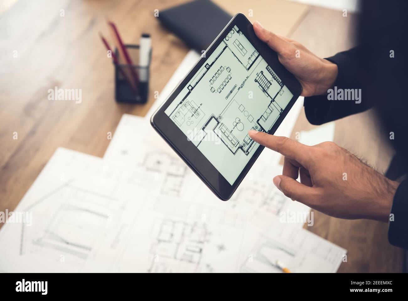 Real estate agent or architect presenting house floor plan to client on ...