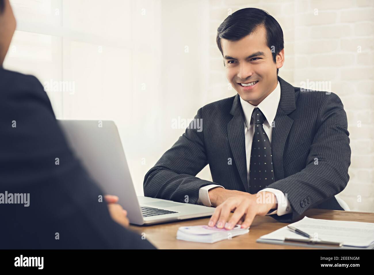 Sly tricky businessman giving money to his partner at working table ...